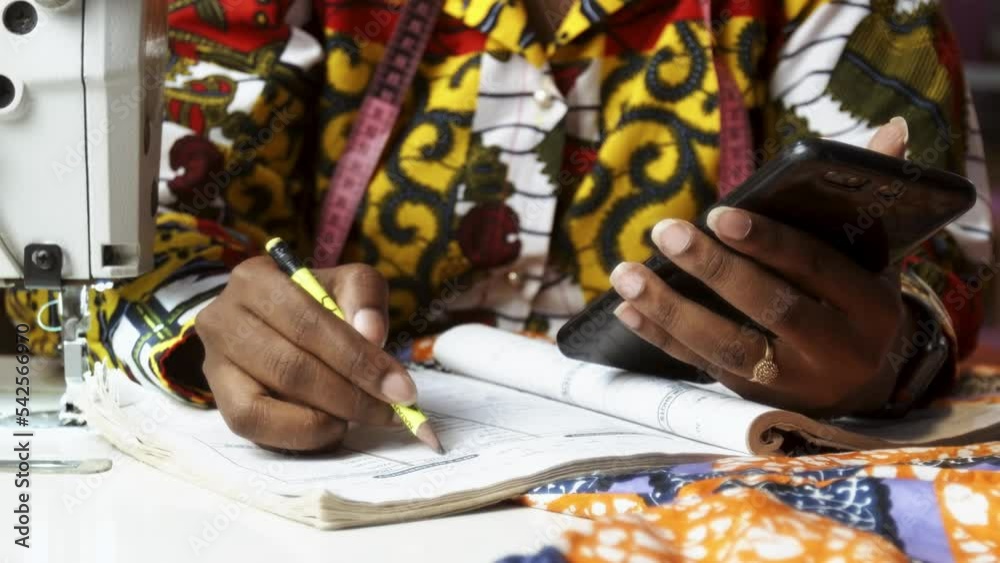 Black African Female Dress Maker Records Measurements of Clothes into ...