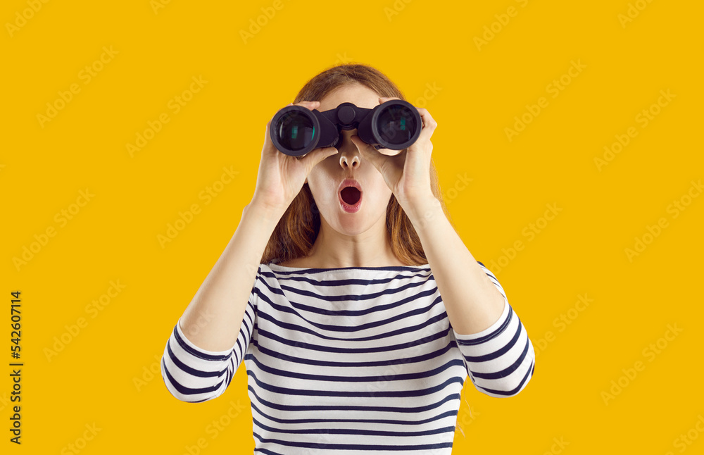What is there. Curious and inquisitive woman peeking through binoculars ...