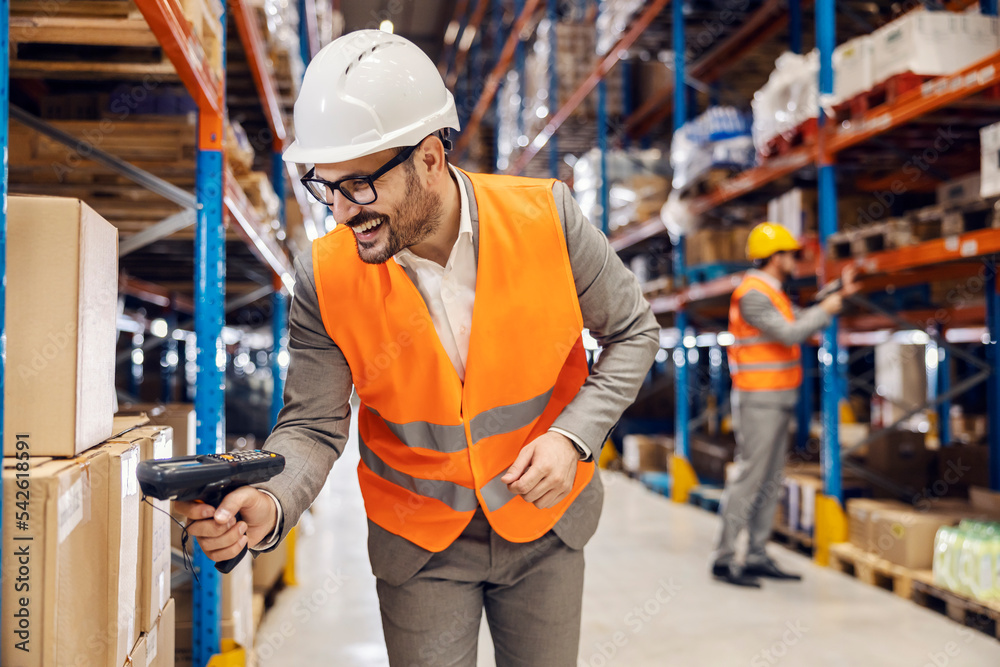 Happy manager is controlling warehouse and loading bar codes and qr ...