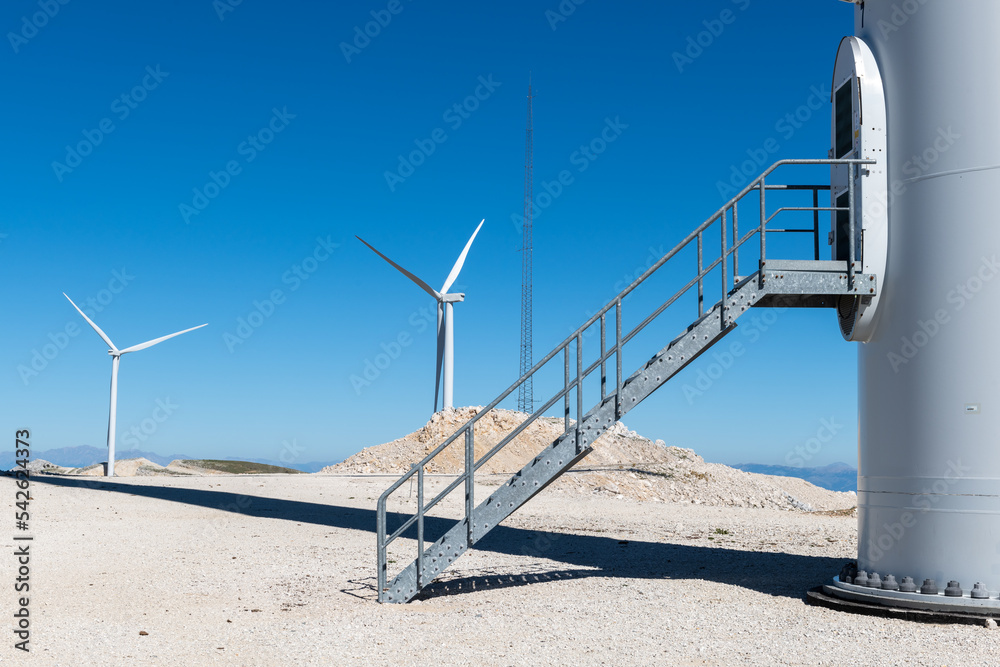 The base of a wind turbine with a flight of stairs and a view of other ...