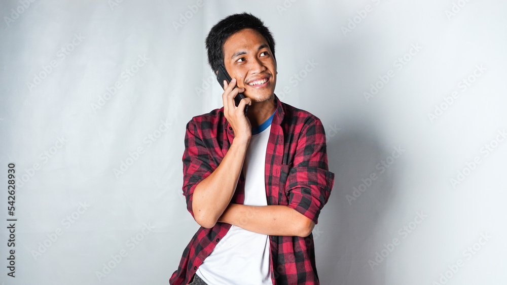 asian adult man wearing red flannel calling someone and get idea with ...