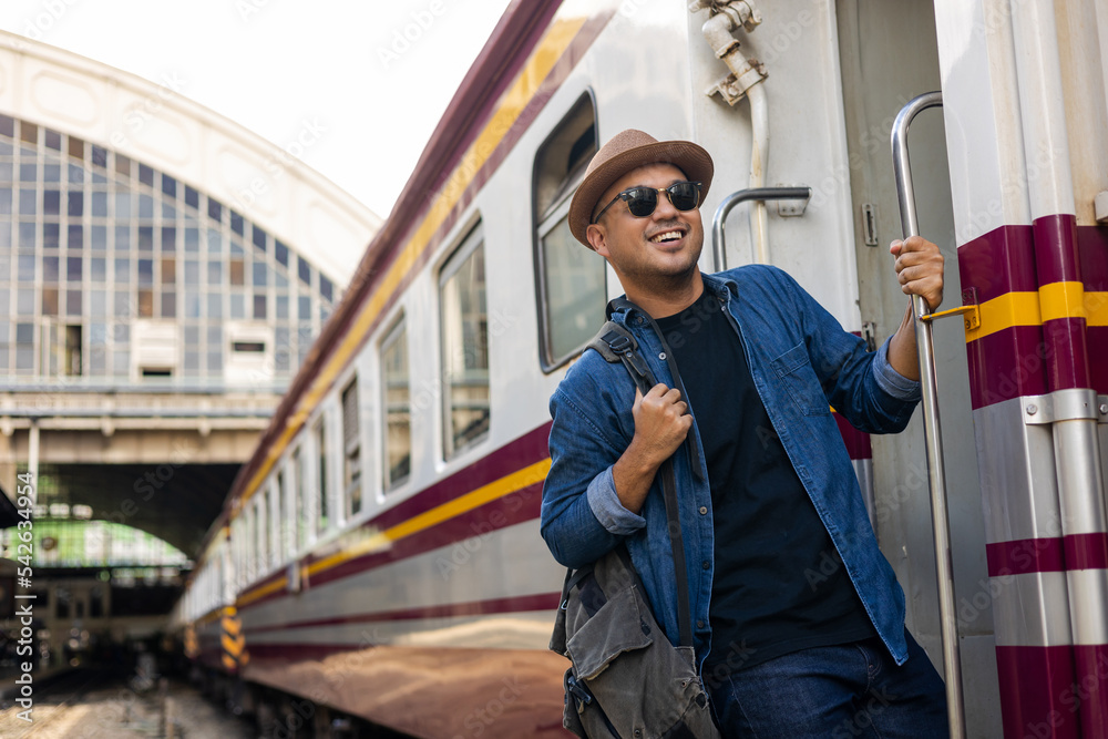 Freedom traveler young asian man hanging handrail on train to ...