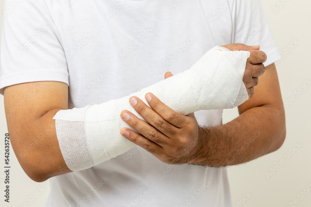 Young man broken arm on isolated background. Asian man put on plaster ...