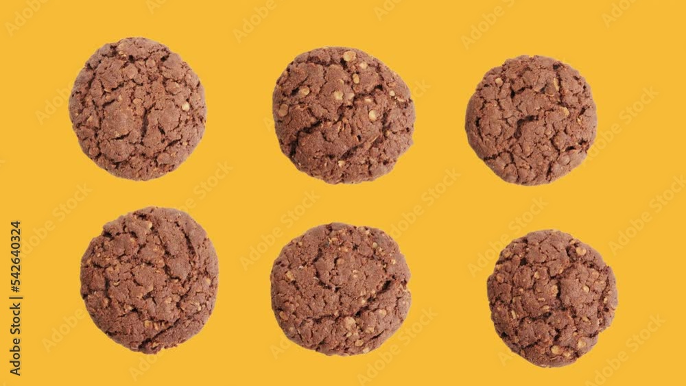 Group of six brown oatmeal cookies rotating at yellow background. Food ...
