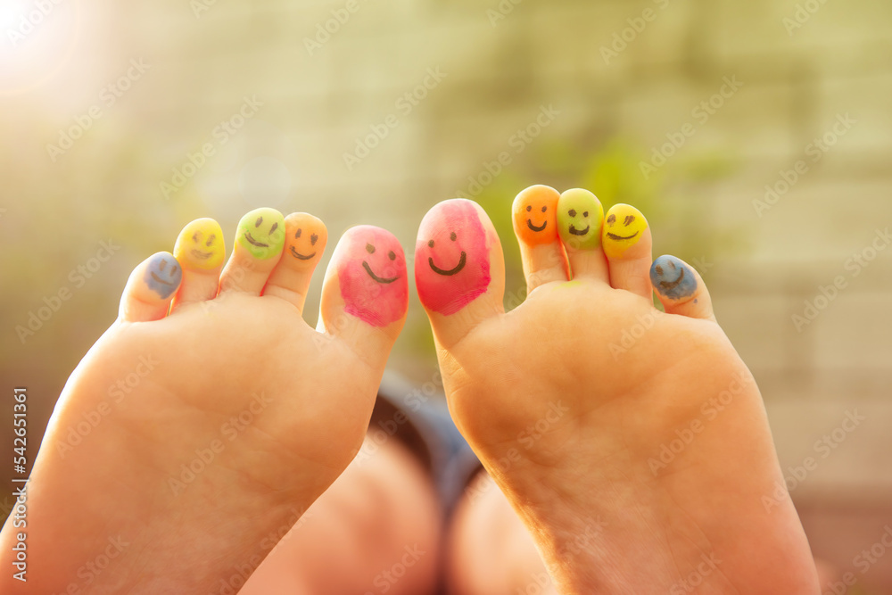Teenage girl with smiling faces drawn on toes outdoors, closeup Stock ...