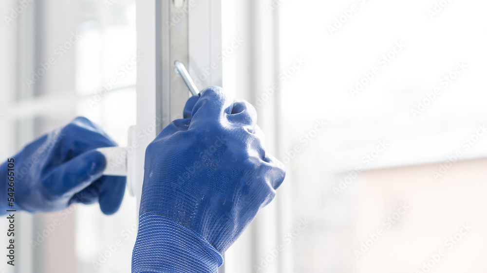 installation of plastic in a frame house, the builder screws the window ...
