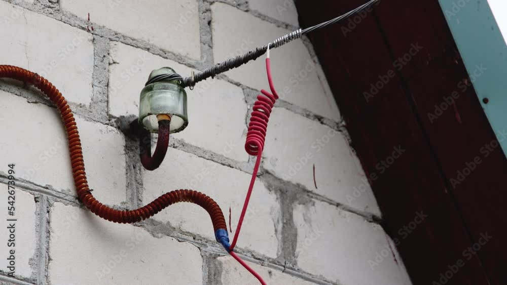 Connecting an electric cable from a pole to a house by air. Mounting ...