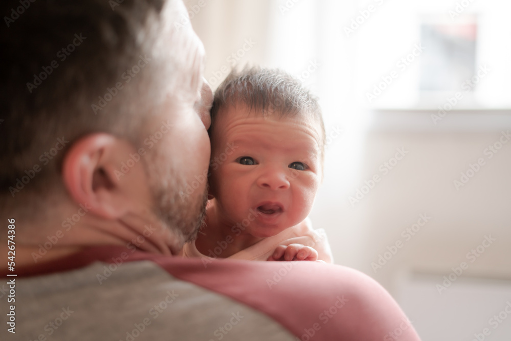 lifestyle portrait of young father holding adorable and beautiful ...