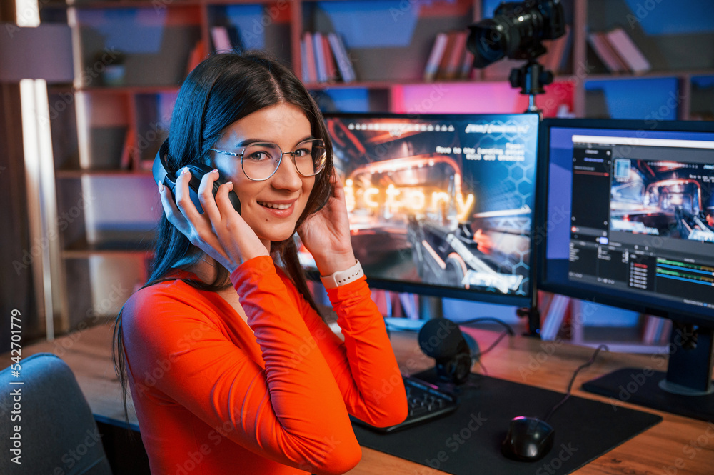 Positive facial expression. Young beautiful game streamer is indoors ...