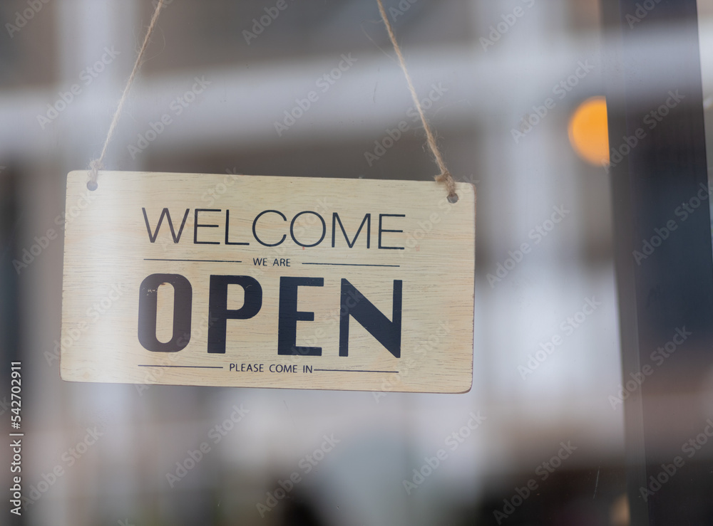 Open sign on the glass door, barista, waitress turning open sign board ...