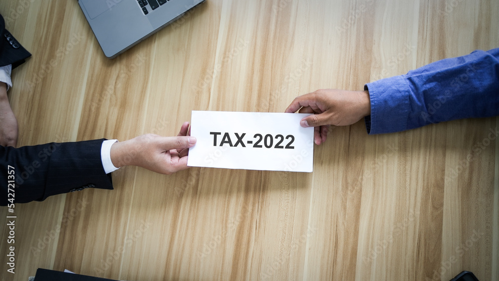Tax word and number 2021 displayed on white paper with taxpayer filing ...