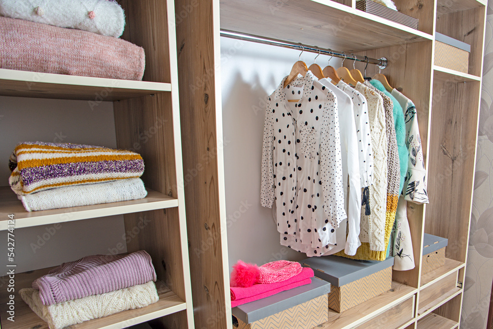 Big wardrobe with different clothes and accessories in dressing room ...