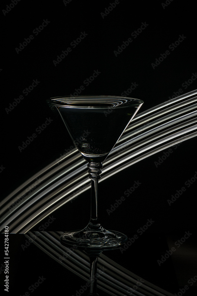 Cocktail glass on a black background with light painting streaks ...