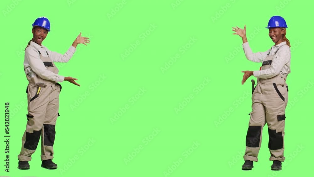 Smiling builder advertising something on full body greenscreen ...