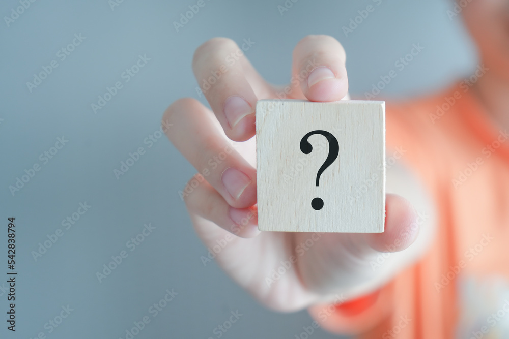 Hand holding question mark symbol on wooden block with copy space. Ask ...