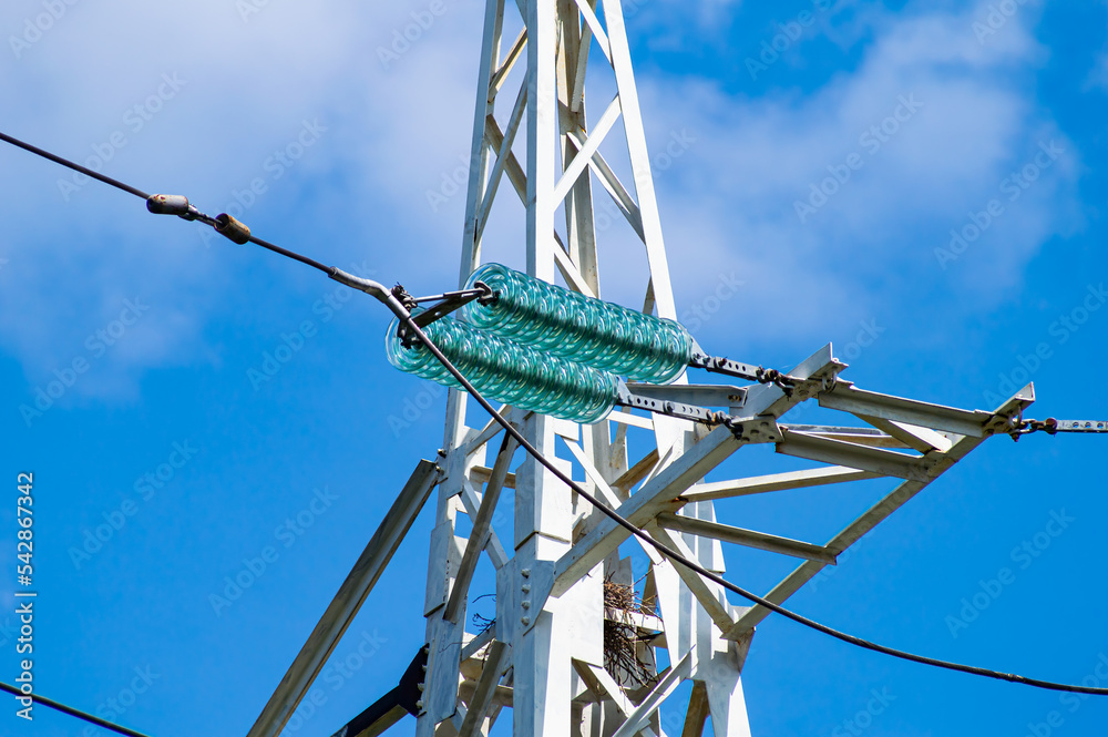 Line insulator on the electrical wires of a high-voltage tower ...