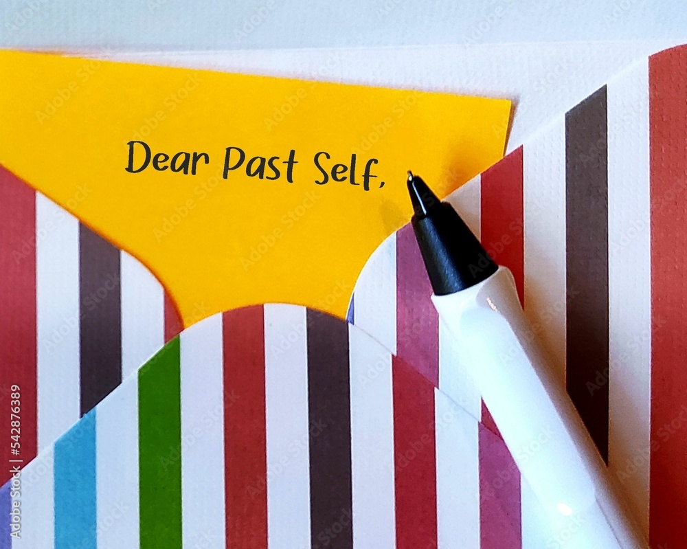 Yellow paper in colorful envelope with handwritten text DEAR PAST SELF ...