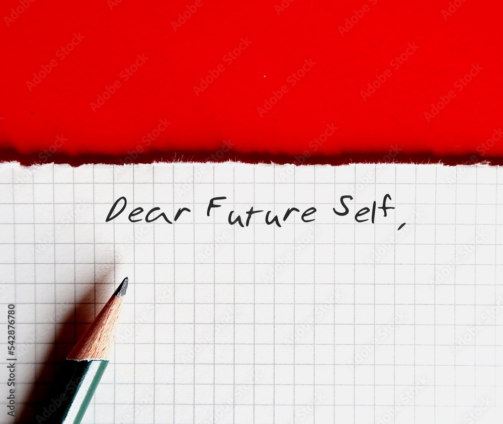 On orange background, torn paper with handwritten text DEAR FUTURE SELF ...