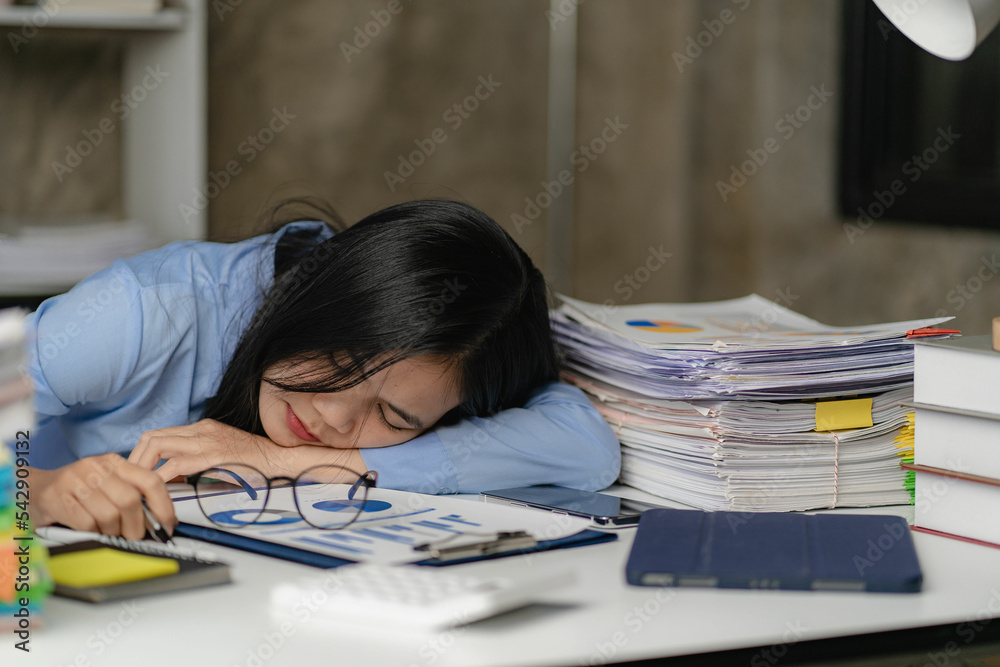 Asian female worker working overtime in the office late at night The ...