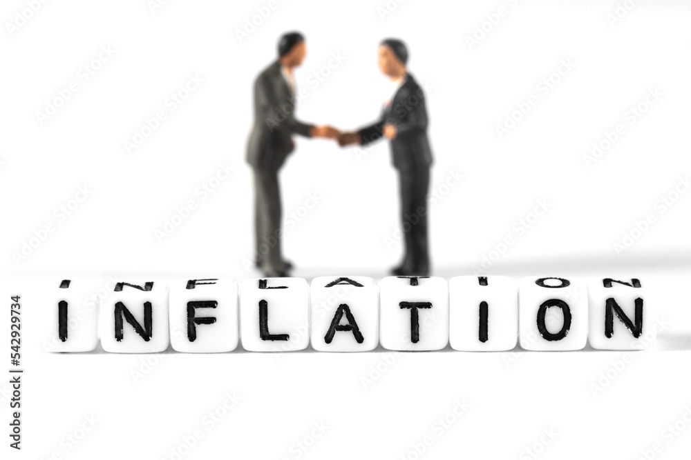 Inflation on beads with two scale model businessmen, shaking hands, in ...