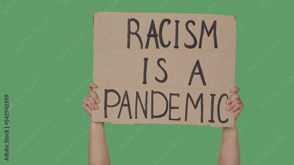 Hands of men raising up cardboard poster RACISM IS A PANDEMIC. Stop ...