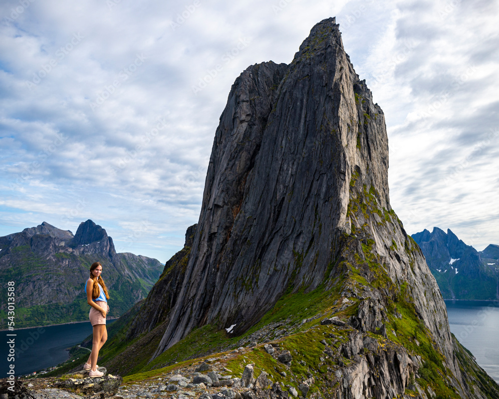 beautiful girl stands on the rocks above the precipice enjoying the ...