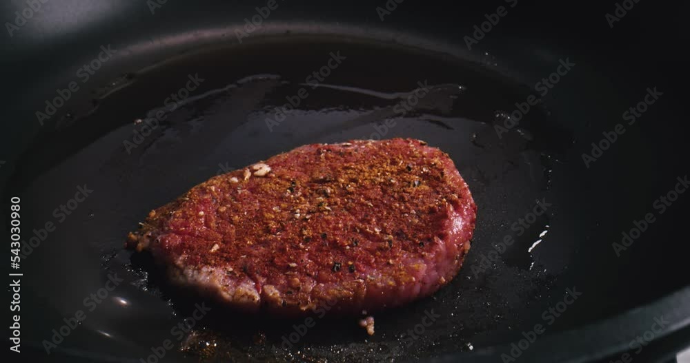 Beef stakes frying in pan. Close up cooking of dressed and seasoned ...