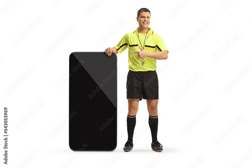 Full length portrait of a football referee standing next to a big ...