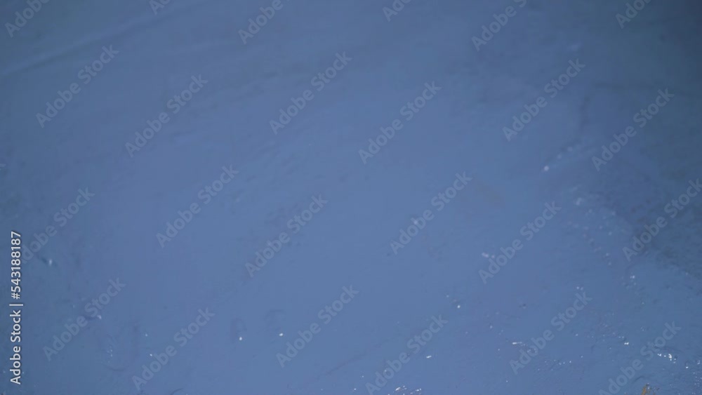 Application of blue waterproofing in the bathroom. A worker applies ...