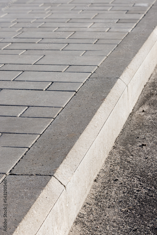 Paved with paving slabs, the footpath is separated from the asphalt ...