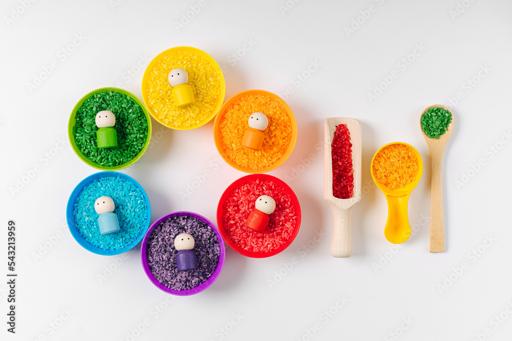 Bowls in rainbow colors with colored rice and scoops. Sensory bin ...