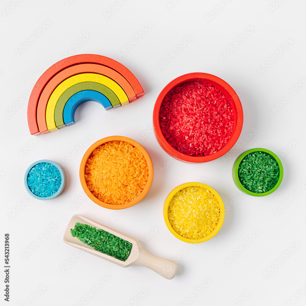 Bowls in rainbow colors with colored rice and scoops. Sensory bin ...