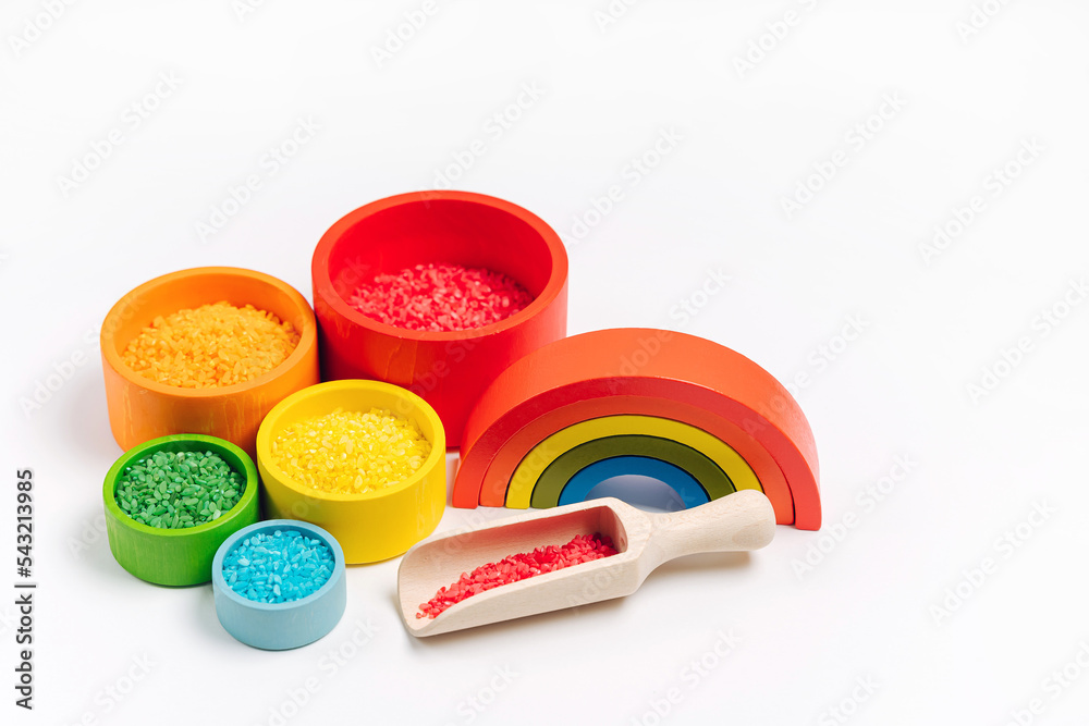 Bowls in rainbow colors with colored rice and scoops. Sensory bin ...