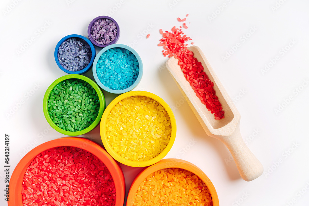 Bowls in rainbow colors with colored rice and scoops. Sensory bin ...