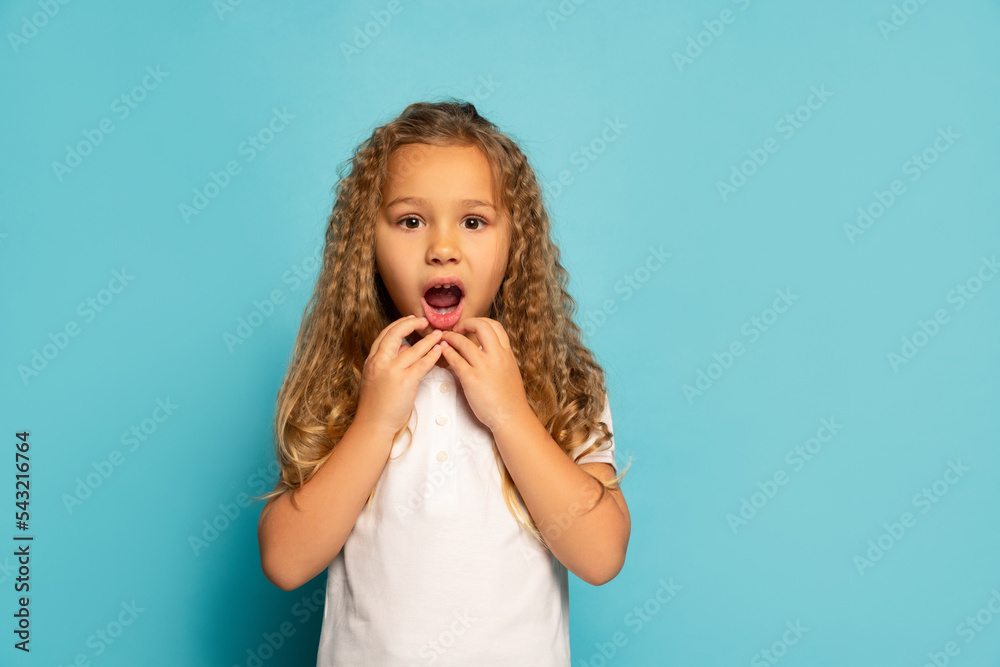 Surprised child. Cute little girl, kid with long curly hair looking at ...