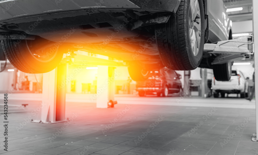 Change motor oil in auto service garage. Car is on lift, lubricant is ...