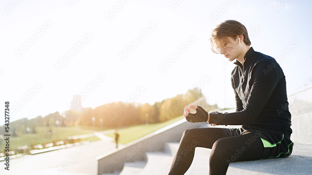 Man sitting on the steps after taking a break from morning jogging with ...