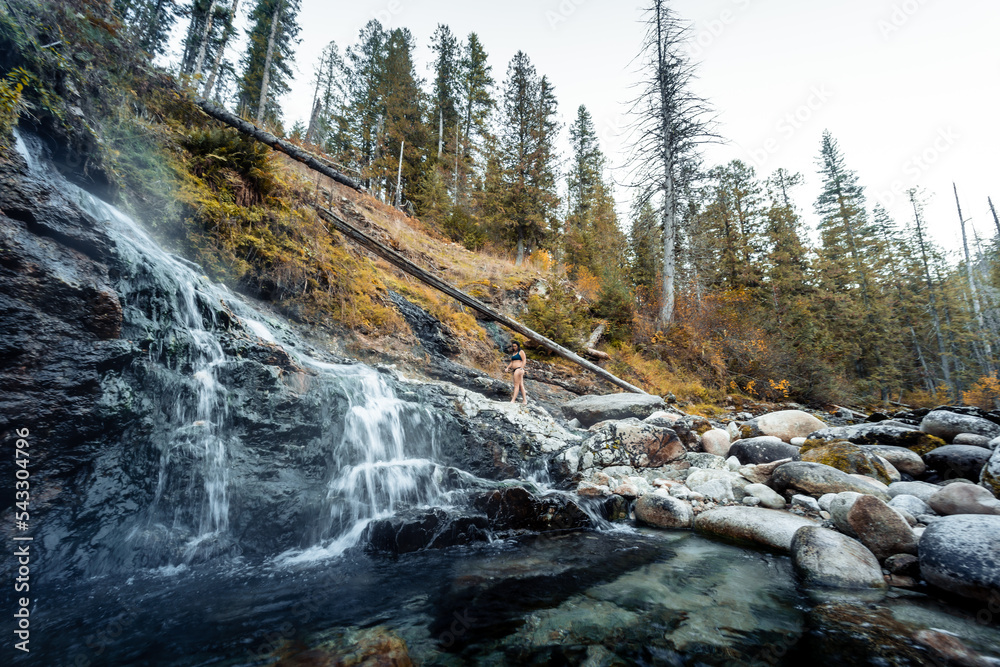 Horizontal image of Woman walking near cascading hot waterfalls to ...