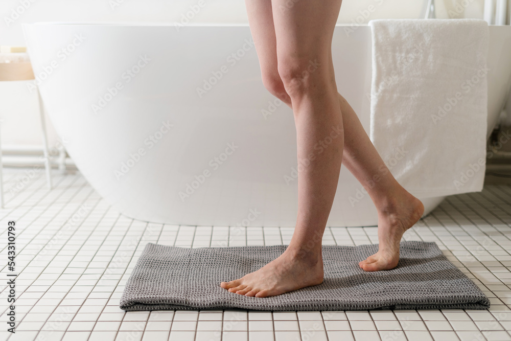 Young woman with perfect smooth legs standing on shower mat Stock Photo ...
