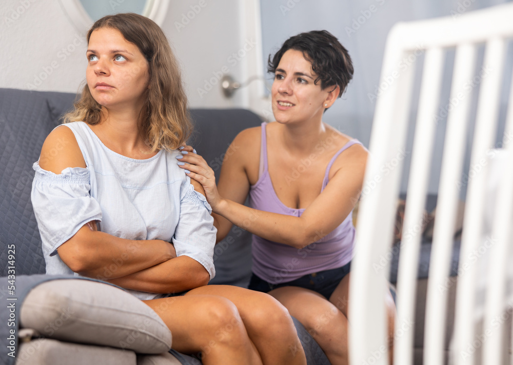Sad offended young woman ignoring her wife comforting her and asking ...