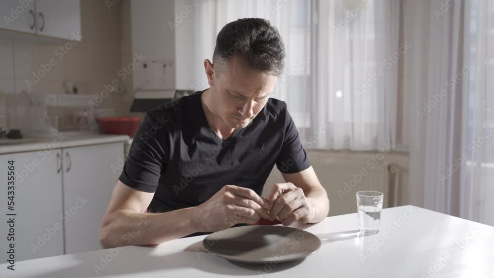 Food scarcity and malnutrition. The man eats a slice of bread and ...