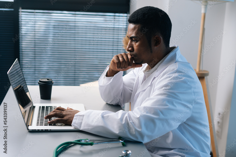 Side view of confused black male doctor wearing white coat uniform ...