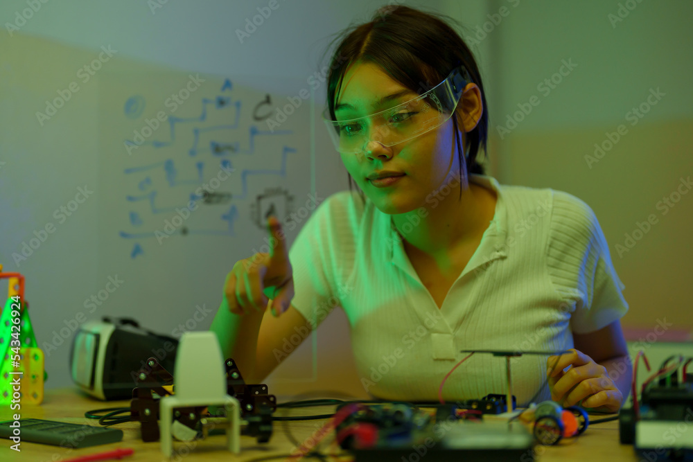 Asian teenager is learning electronics and soldering wires and circuit ...