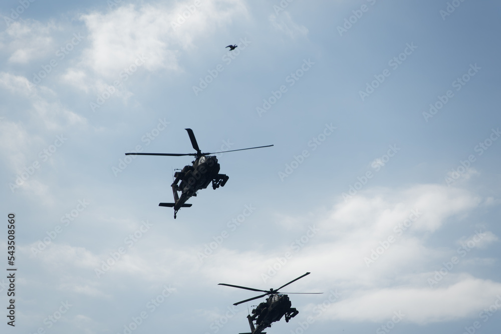 Boeing AH-64 attack helicopters on formation during an air show. Greek Air Force Apache flying ...