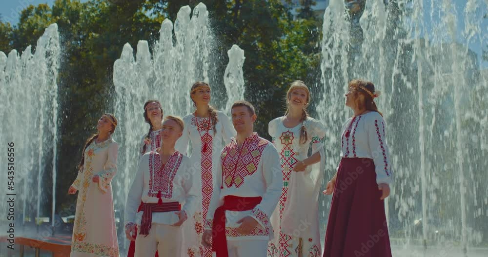 Ukrainian women and men in national folk costumes with embroidery are ...