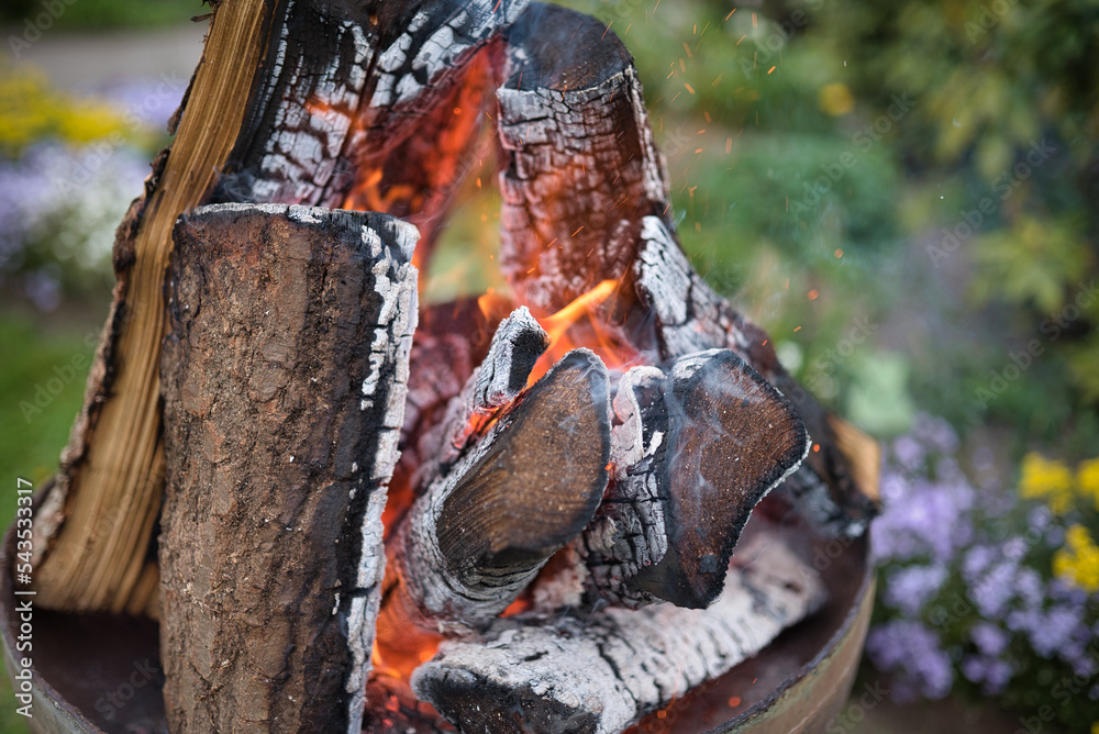Foto de Stacks of logs are burning in a fire barrel at a medieval ...