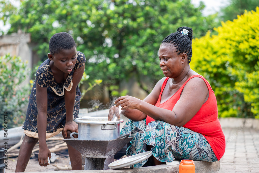 image of african mother and her daughter in local kitchen- black woman ...