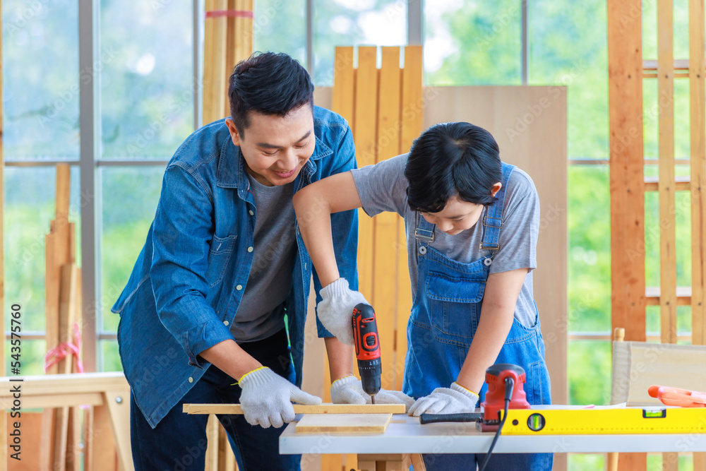 Asian cheerful male dad and son carpenter woodworker colleague in jeans ...