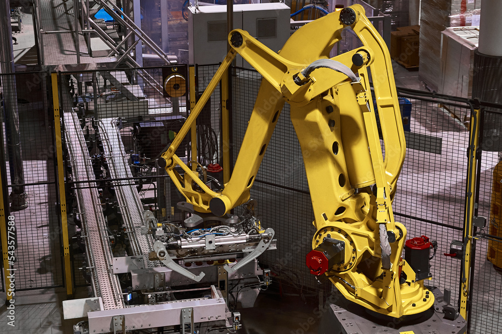 Yellow robotic arm equipped with a crate gripper. Stock Photo | Adobe Stock