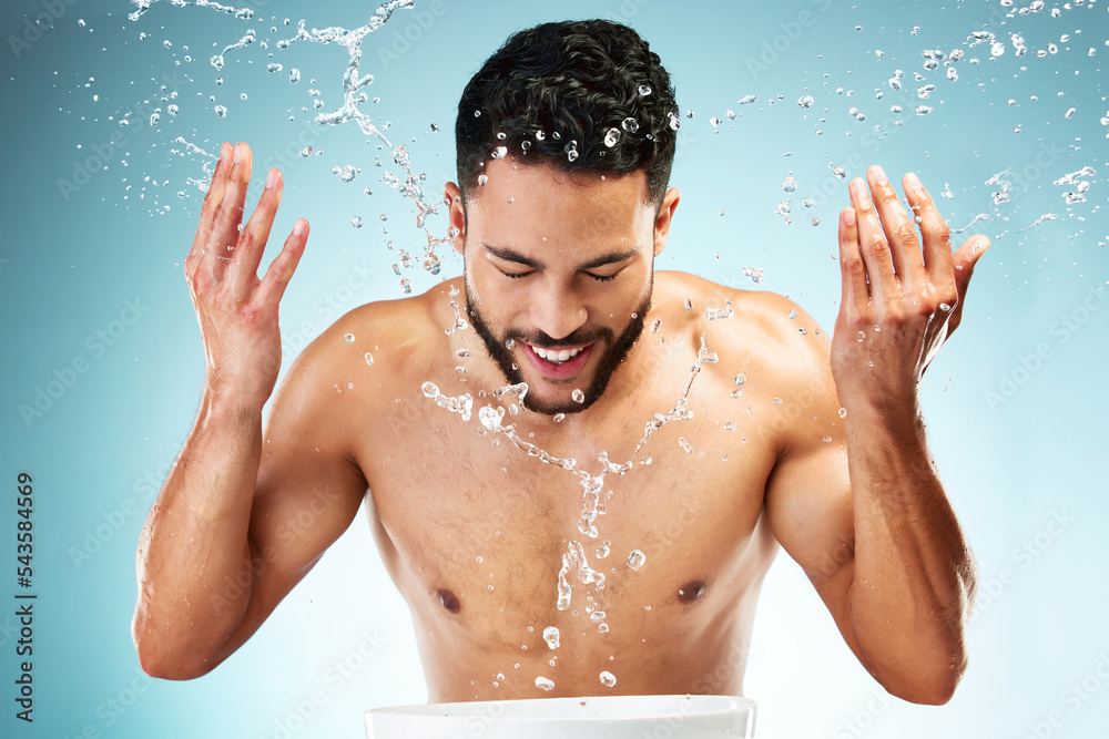 Studio, water splash and face skincare of man isolated against a blue ...